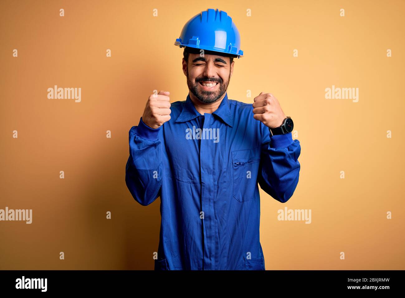 Mechanic man with beard wearing blue uniform and safety helmet over ...