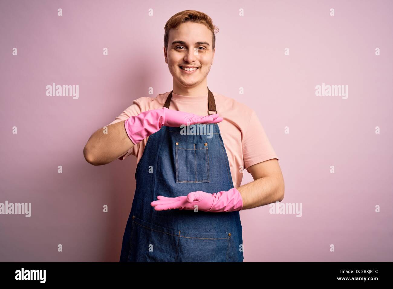 Young Handsome Redhead Cleaner Man Doing Housework Wearing Apron And Gloves Gesturing With Hands