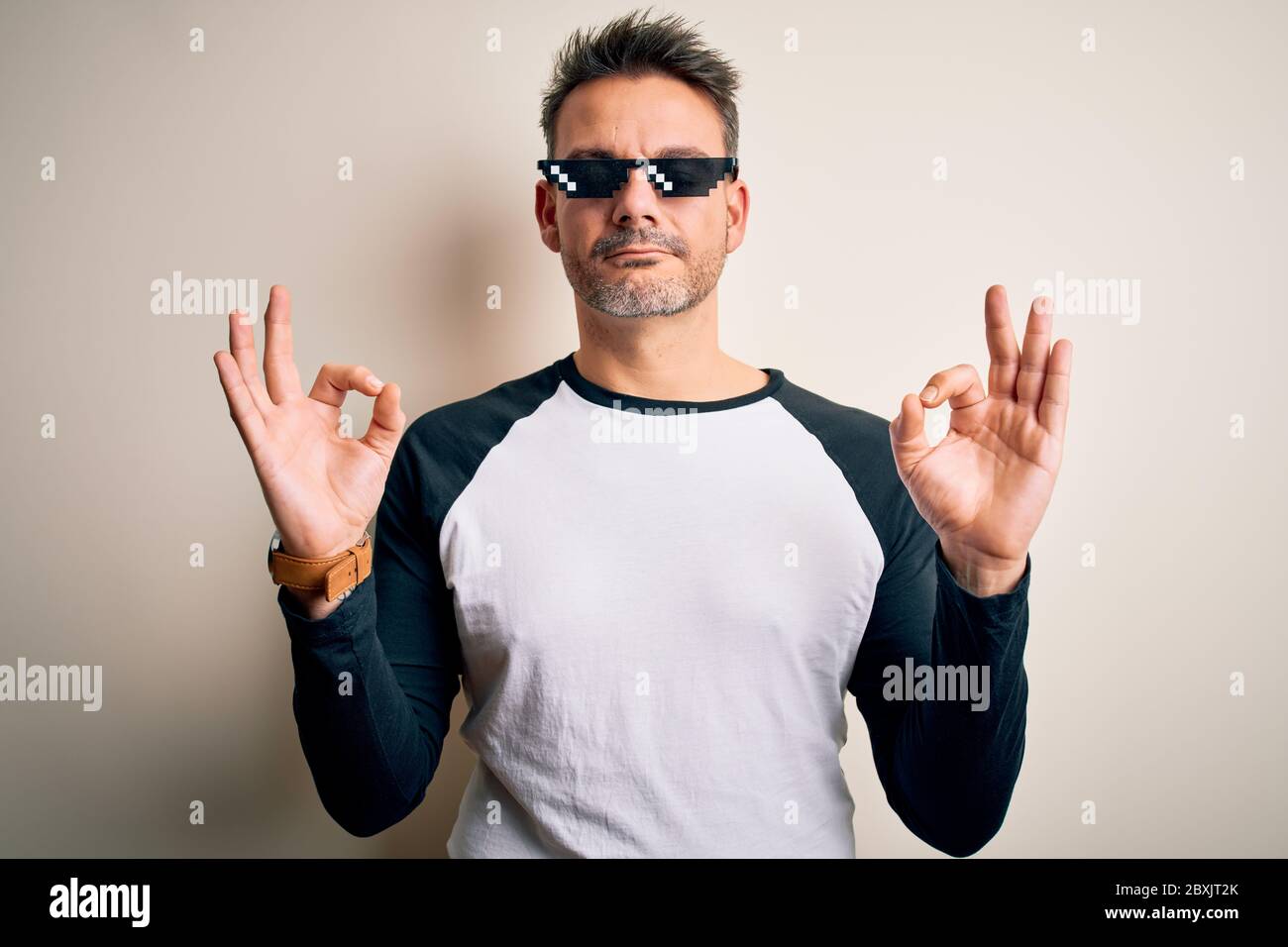 Young Handsome Man Wearing Funny Thug Life Sunglasses Meme Over White