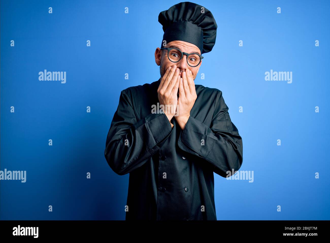 Young handsome chef man wearing cooker uniform and hat over isolated ...