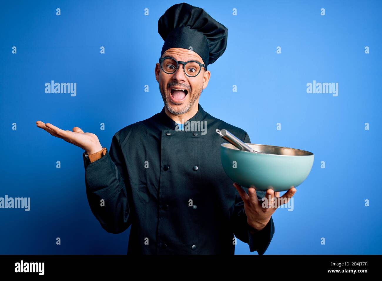 Young handsome chef man wearing cooker uniform and hat mixing using ...