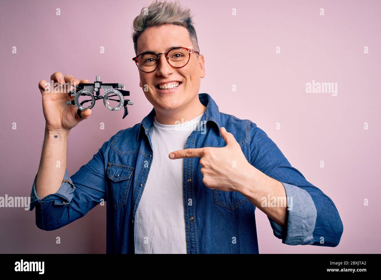 Young modern optical optomestrist man holding optometrical glasses over ...