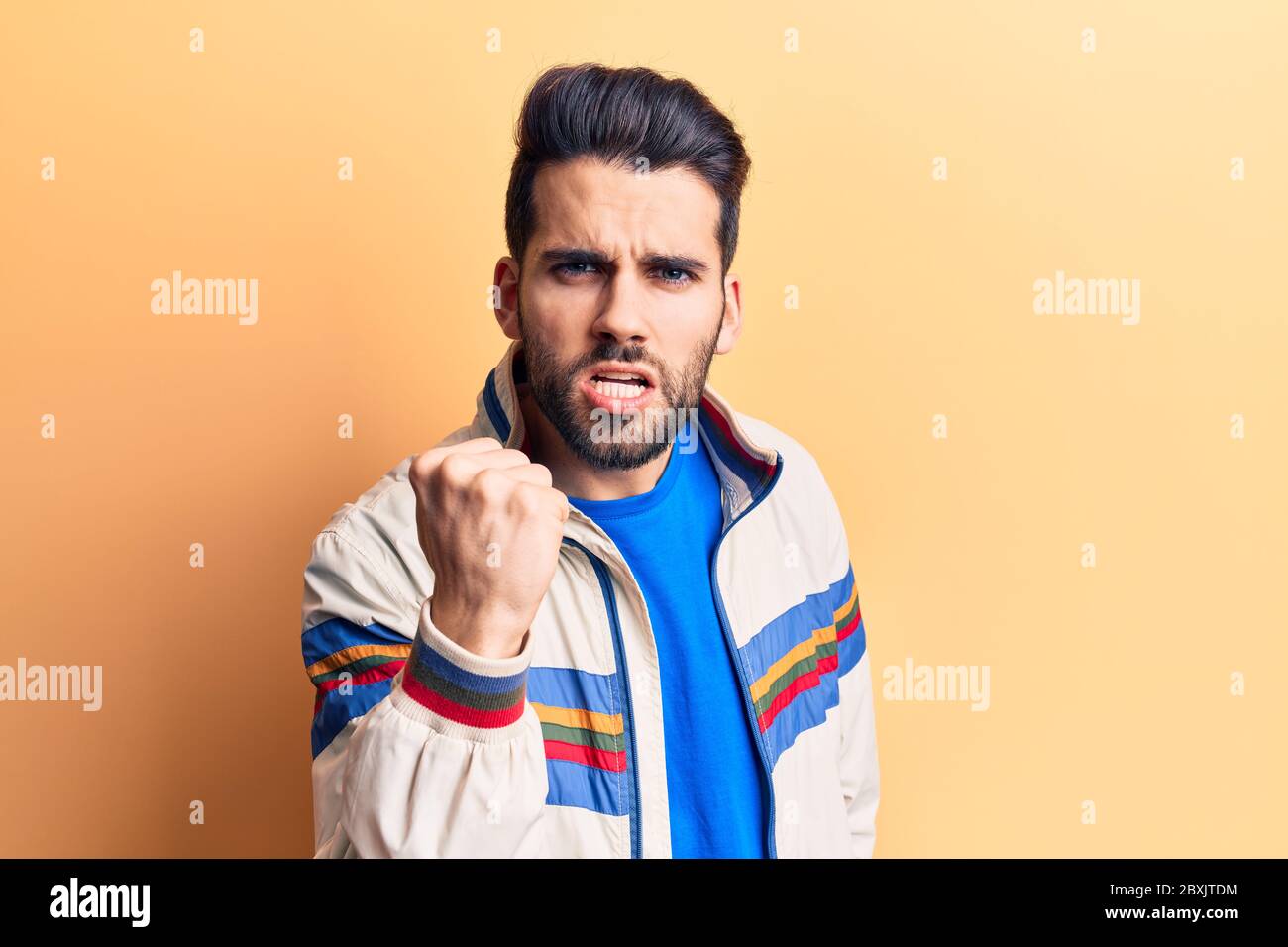 Young handsome man with beard wearing casual jacket angry and mad ...