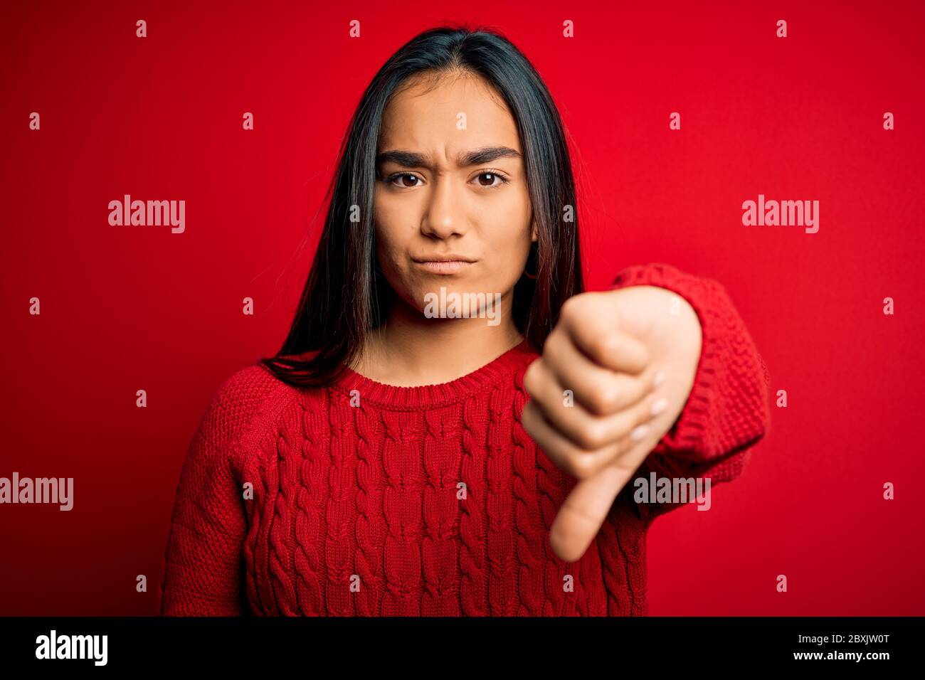 Young beautiful asian woman wearing casual sweater standing over ...