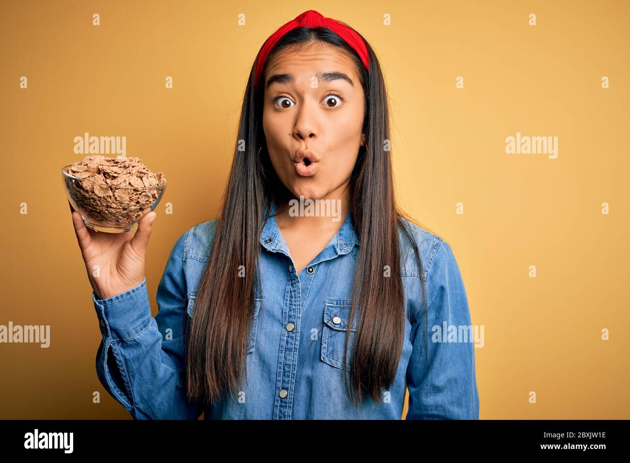 Beautiful asian woman holding bowl with healthy corn flakes cereals ...