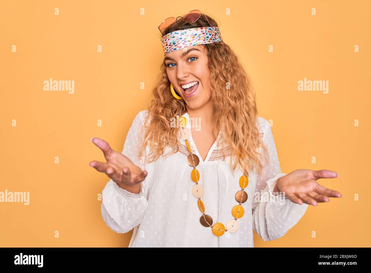Young beautiful blonde hippie woman with blue eyes wearing sunglasses ...