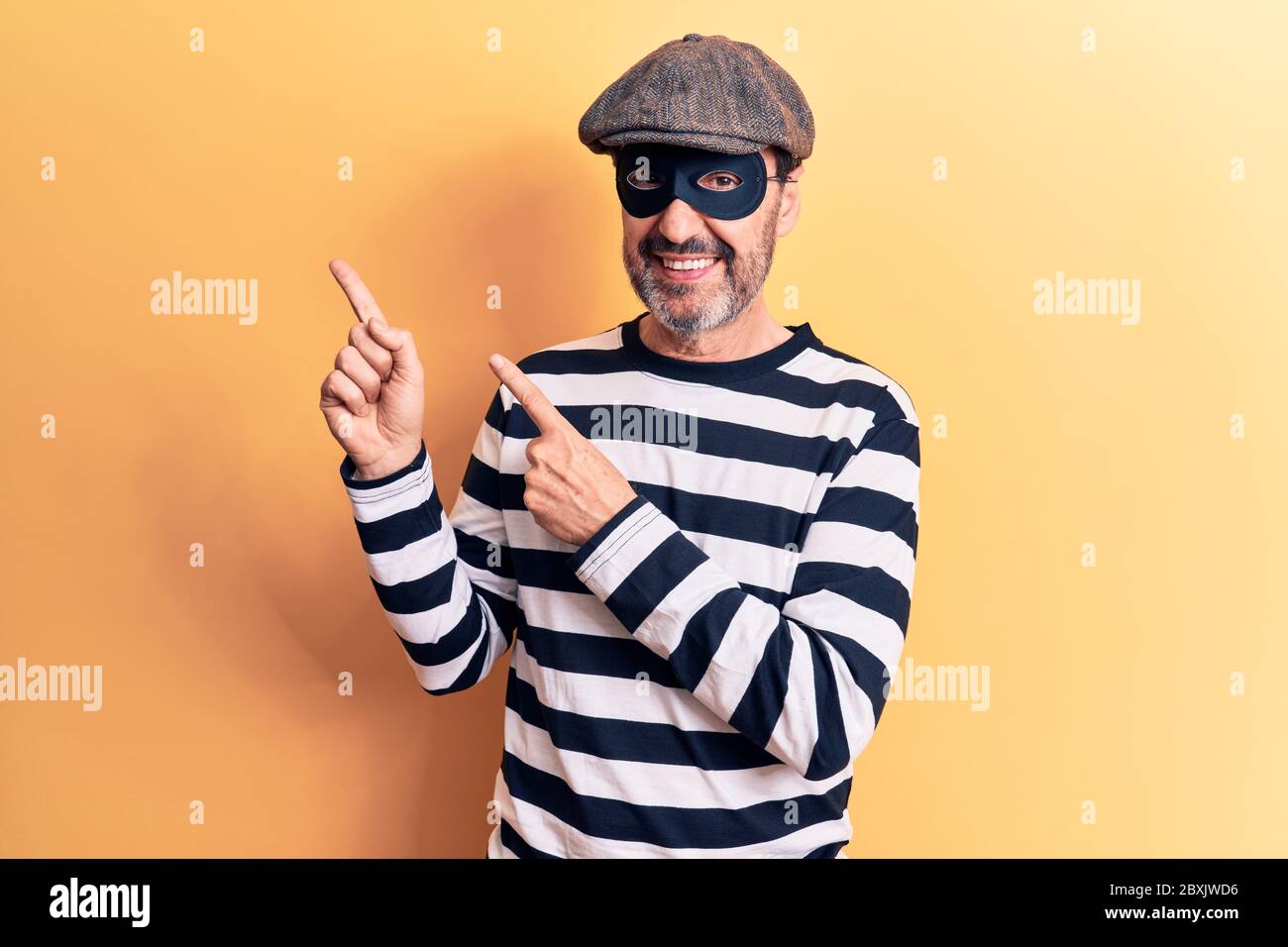 Middle age handsome burglar man wearing cap and mask over isolated ...