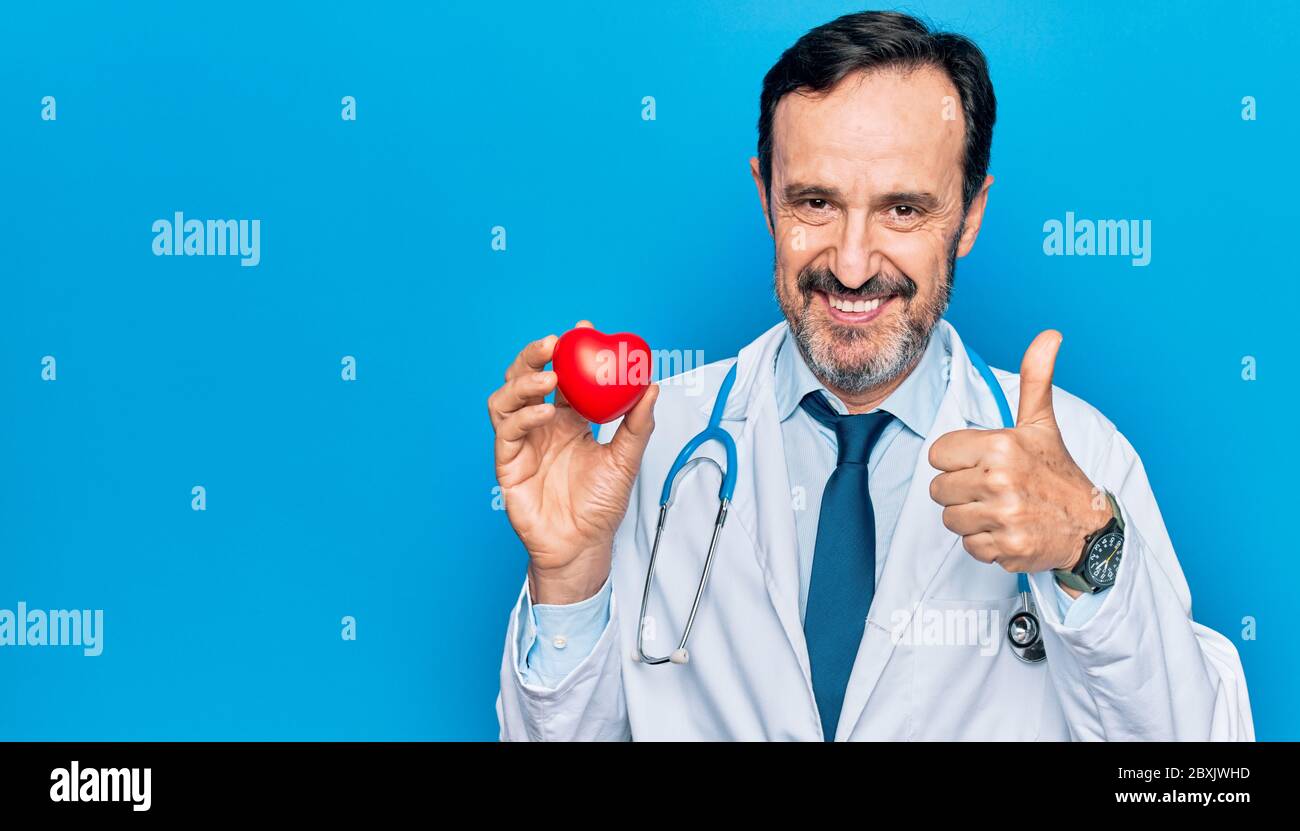 Middle age handsome cardiologist man wearing stethoscope holding ...