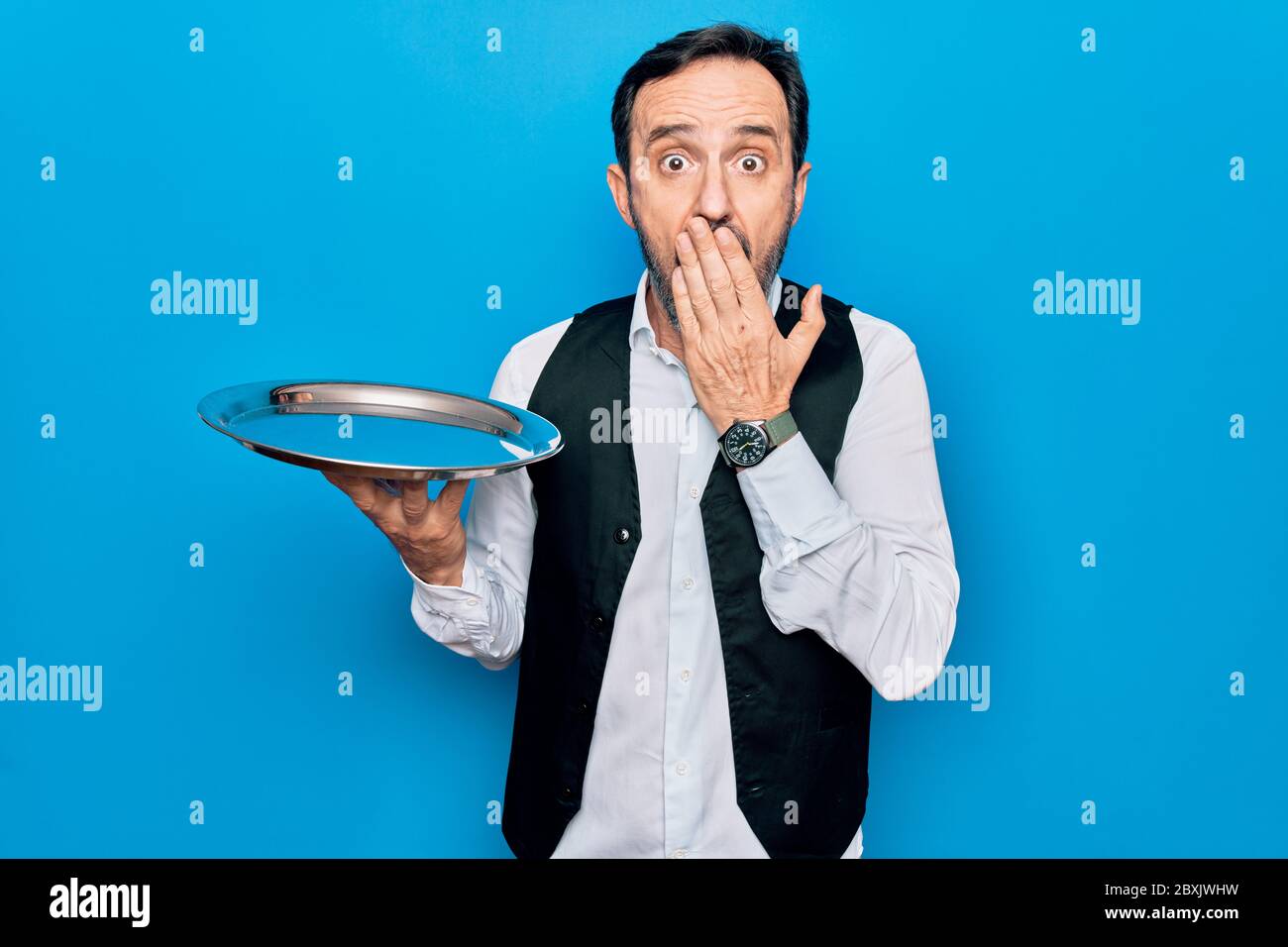 Middle age handsome waitress man holding tray standing over isolated ...
