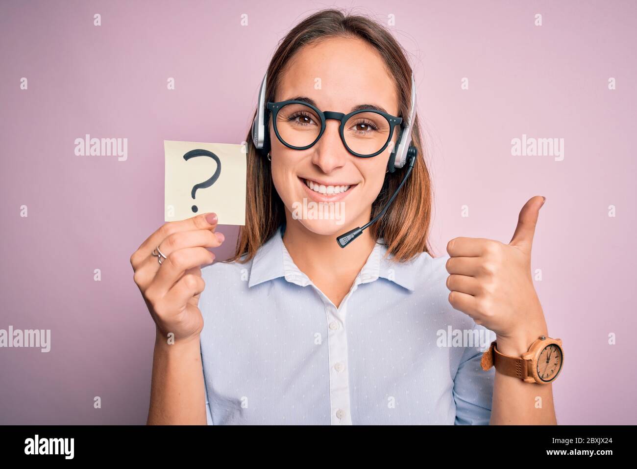Beautiful call center agent woman working using headset holding ...