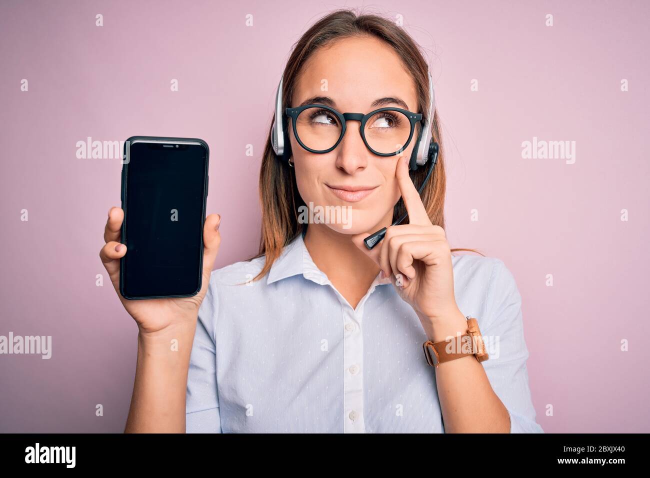 Beautiful call center agent woman working using headset holding ...