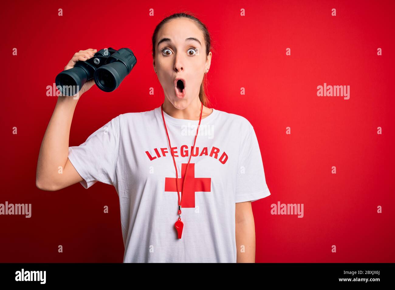 Young beautiful lifeguard woman wearing t-shirt with red cross and ...