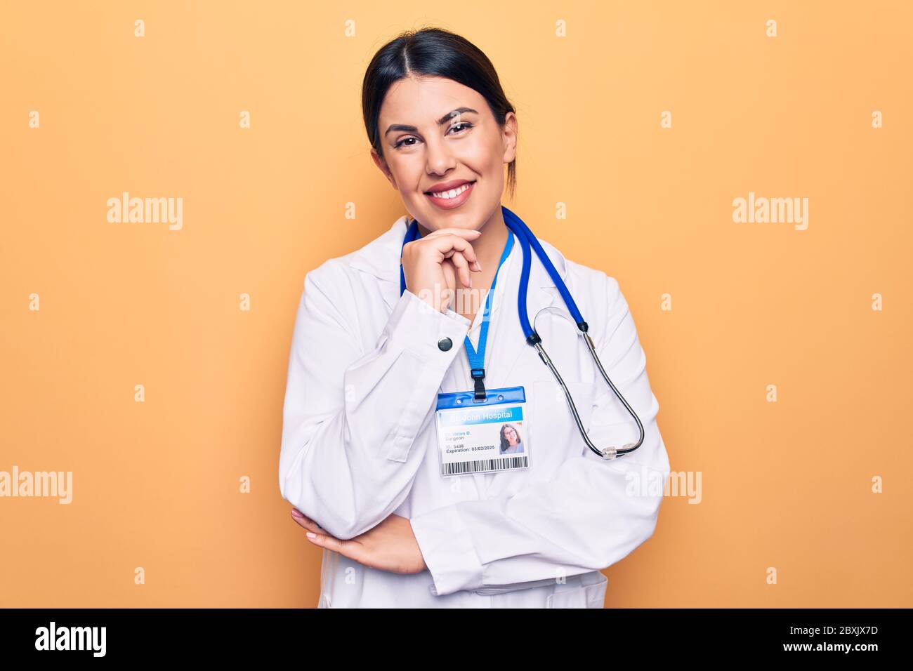 Young beautiful doctor woman wearing stethoscope and id card over ...