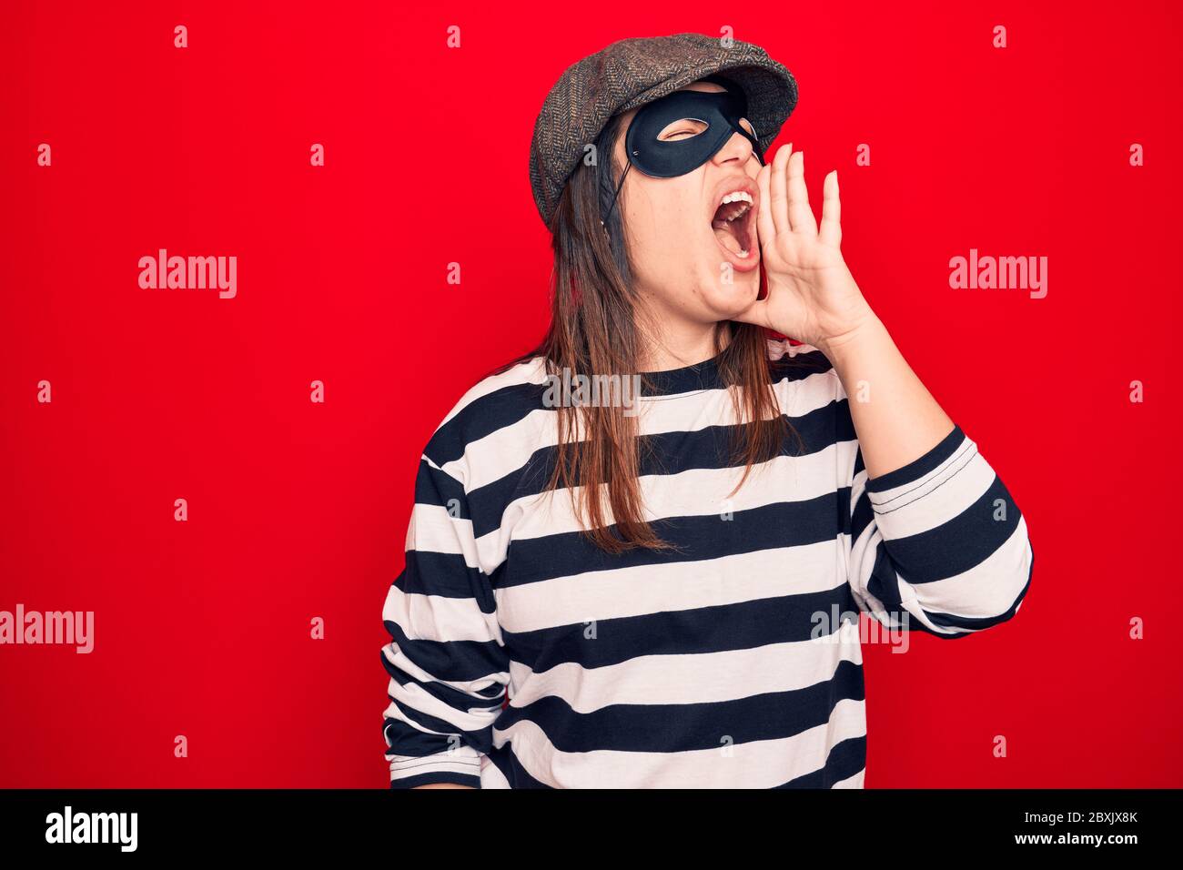 Young beautiful brunette burglar woman wearing cap and mask over ...