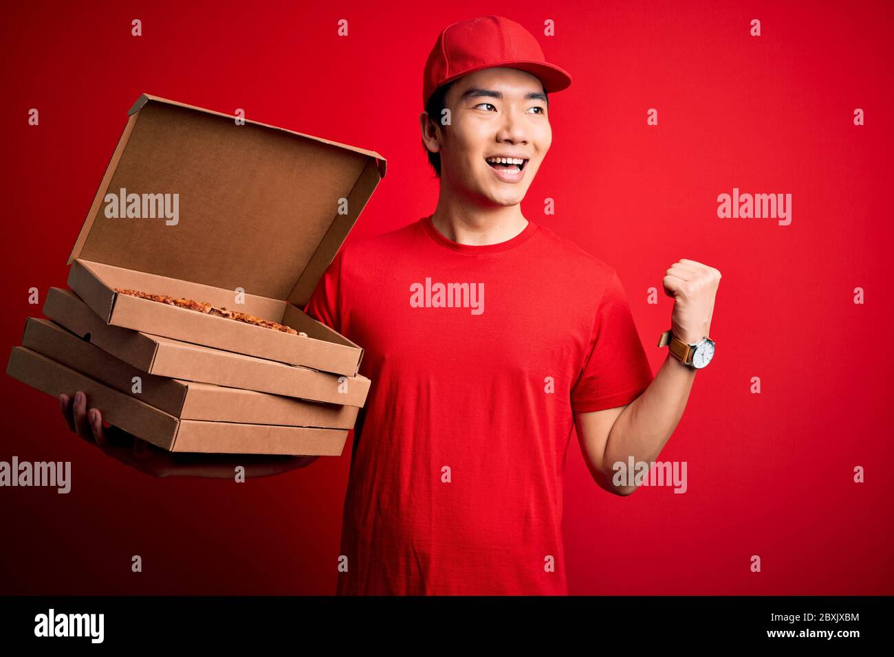 Young handsome chinese delivery man holding deliver boxes with Italian ...