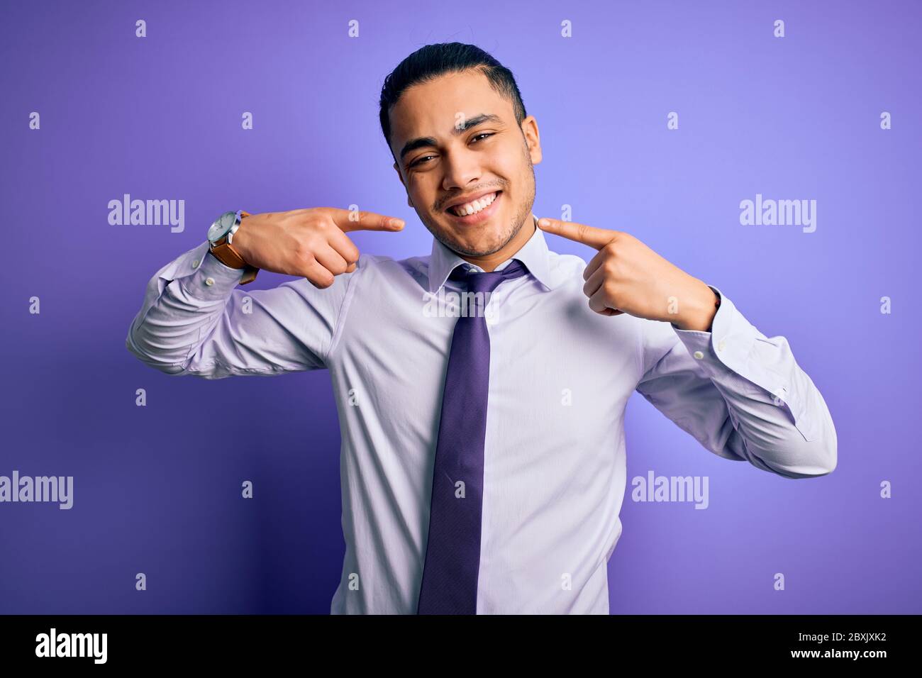 Young brazilian businessman wearing elegant tie standing over isolated ...