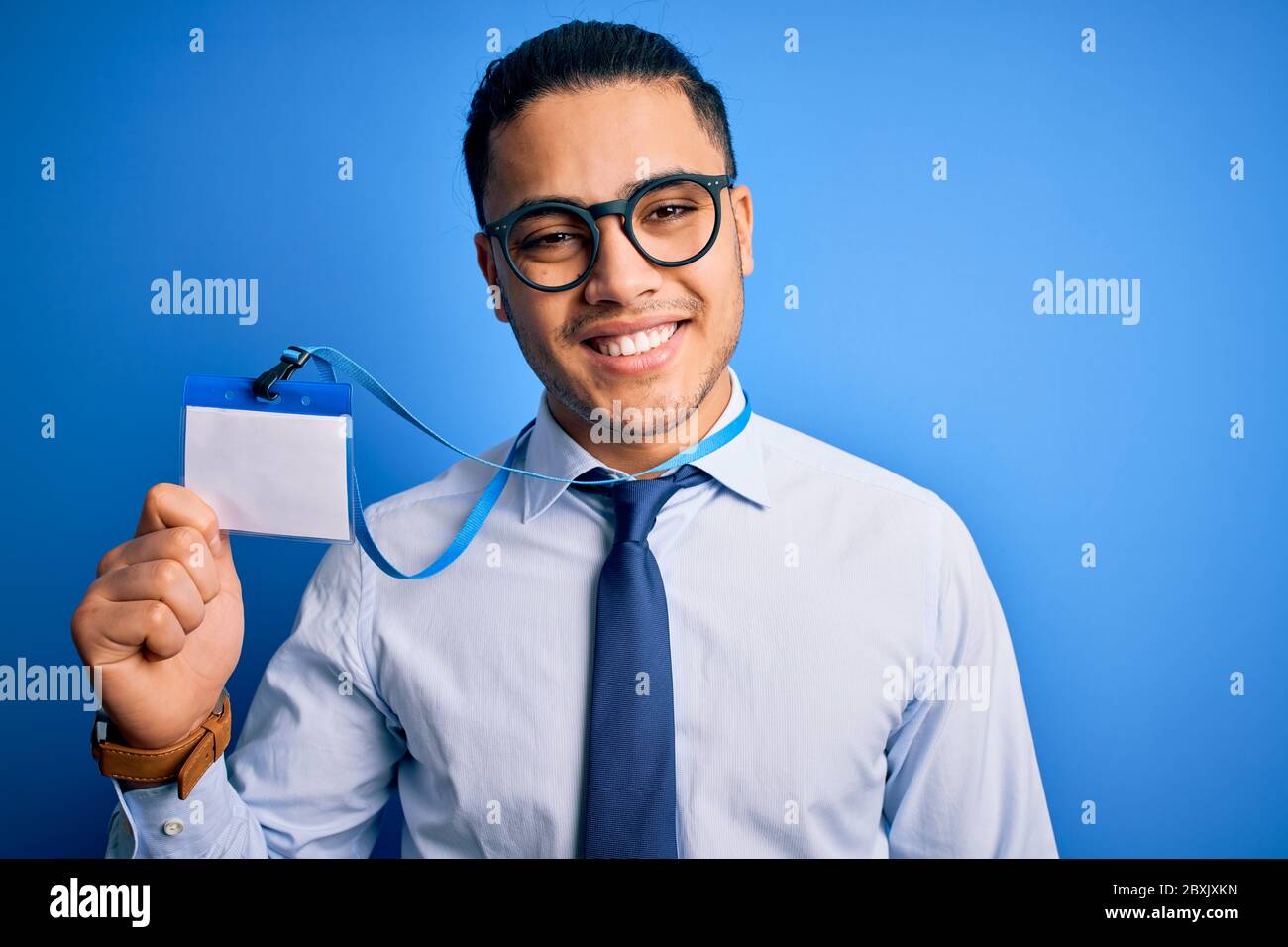 Young brazilian call center agent man holding id identification card ...