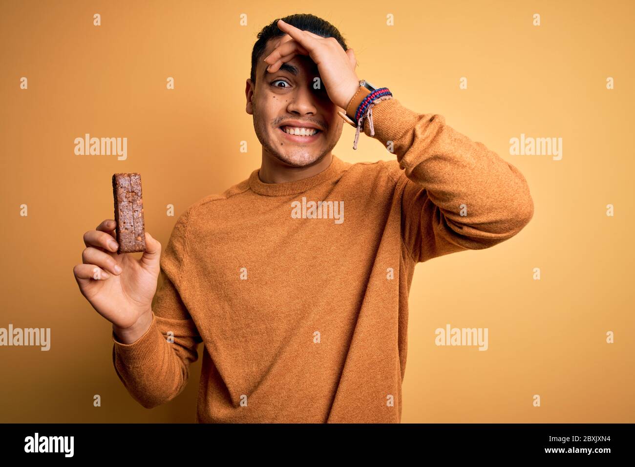 Young brazilian man eating healthy energy bar with protein over ...