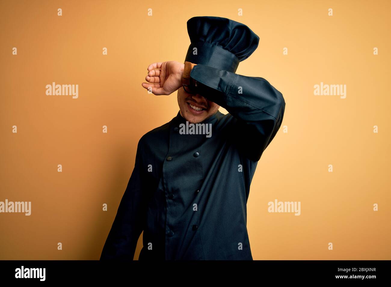 Young brazilian chef man wearing cooker uniform and hat over isolated ...