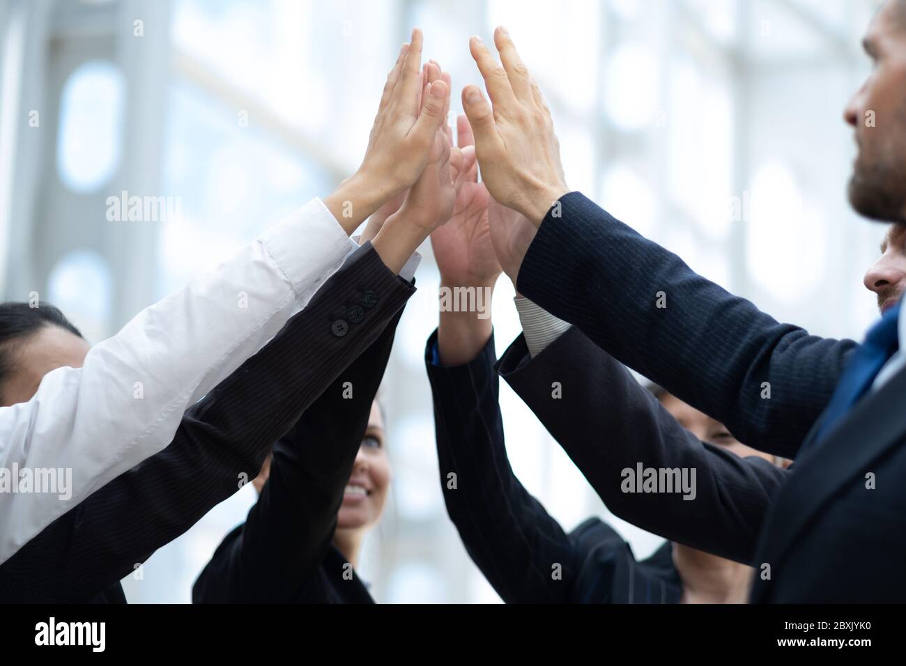 Happy successful multiracial business team giving a high fives gesture ...