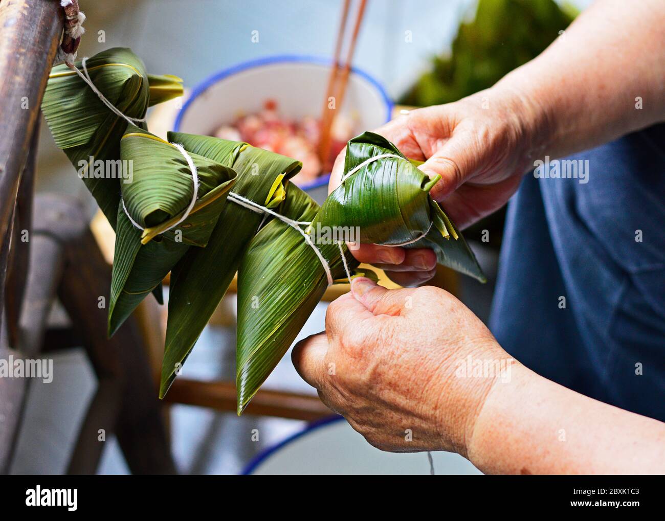 Two Hands Tighten the String Over the Leaf to Make Zong Zi, Chinese ...