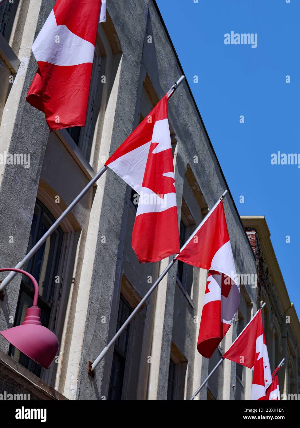 old building with row of Canadian red and white maple leaf flags Stock ...