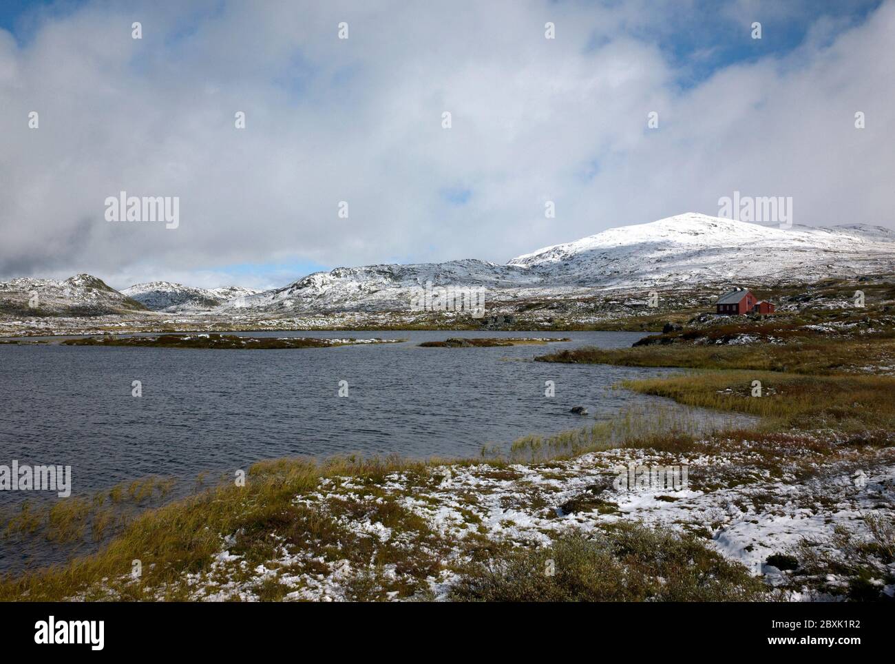 Colour photograph of Lake and mountain cabin in snow-covered landscape ...