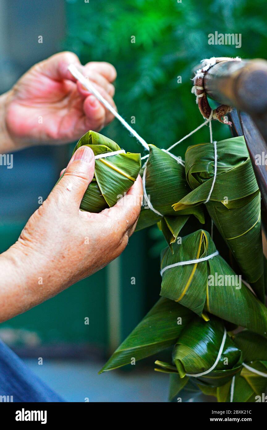 Two Hands Tighten the String Over the Leaf to Make Zongzi, the ...