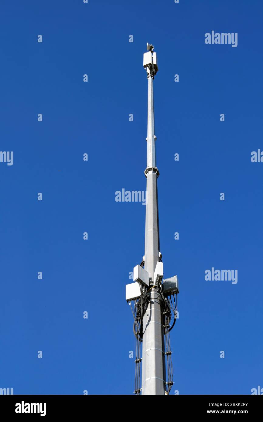 A mast with telecommunication equipment on a background of blue summer ...