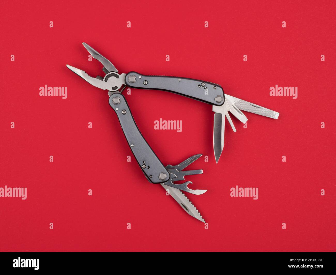 Multitool on a red background closeup Stock Photo - Alamy