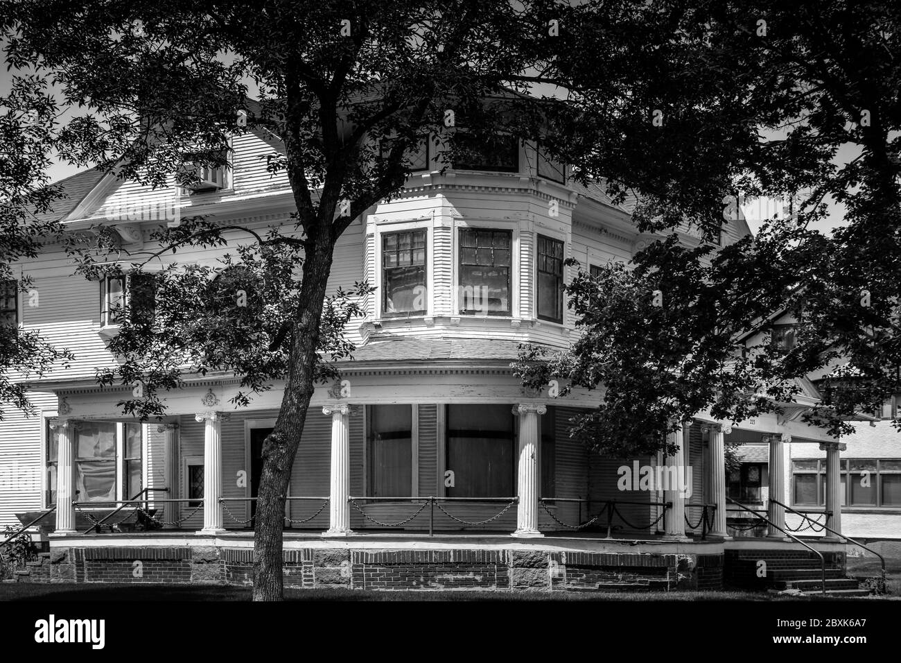 An aging three-story home in a Queen Anne architectural style with it's ...