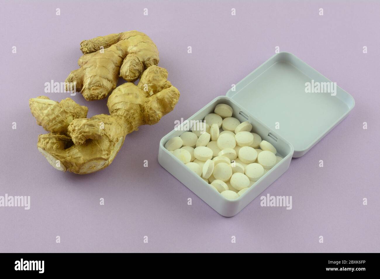 Ginger mints in open metal container and fresh ginger on lavender ...