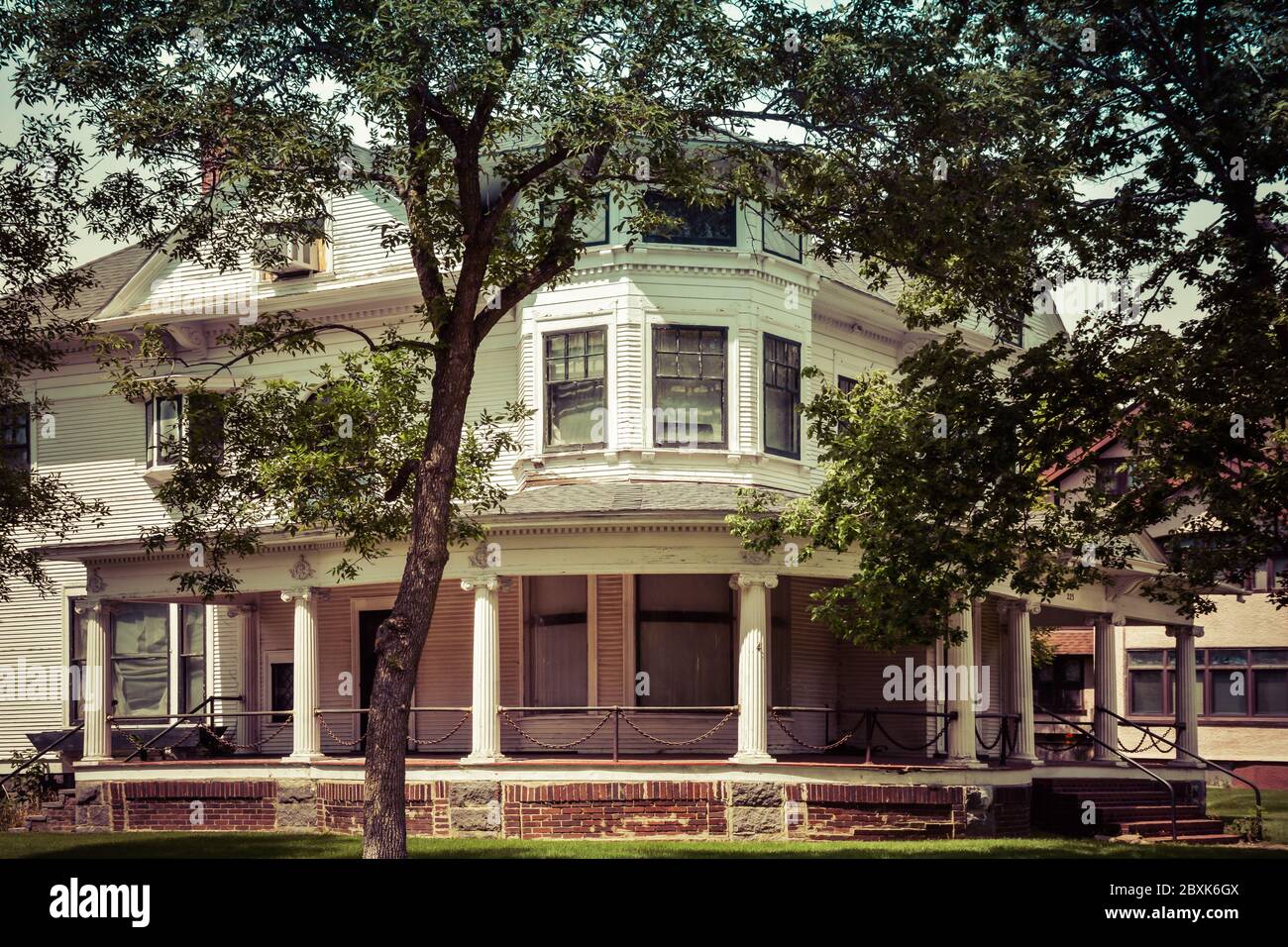 An aging three-story home in a Queen Anne architectural style with it's ...