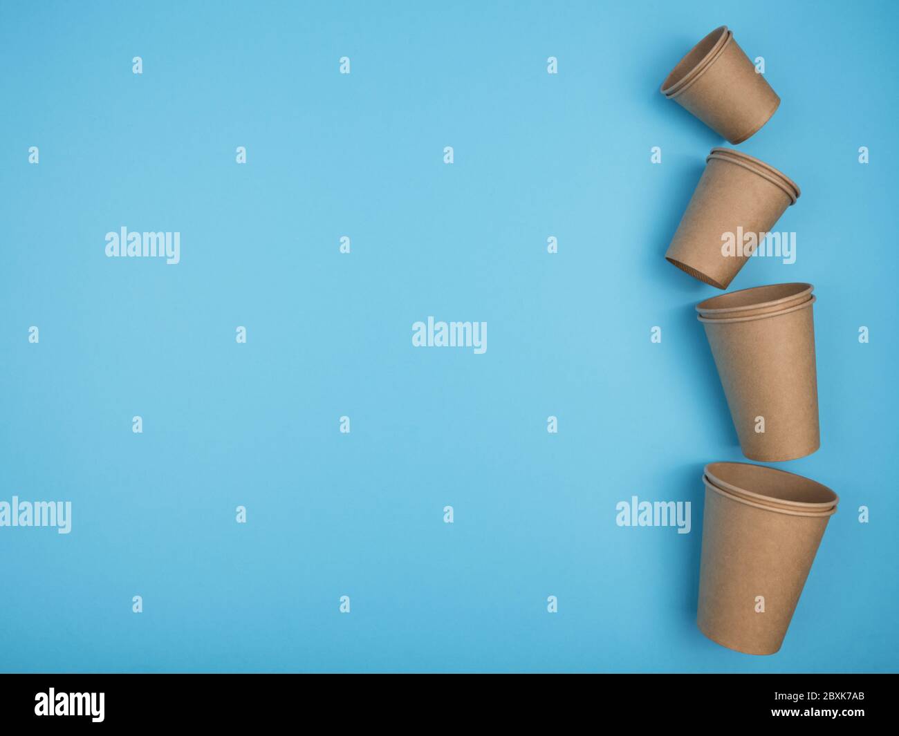 Paper cups on a blue background Stock Photo - Alamy