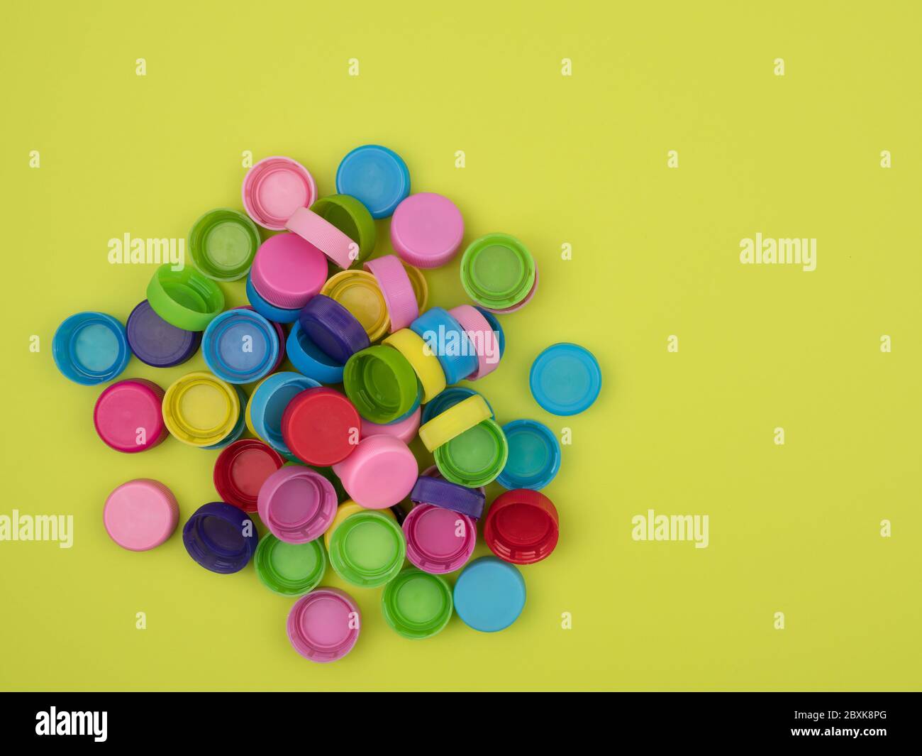 Colorful plastic caps for bottles on a bright green background Stock ...