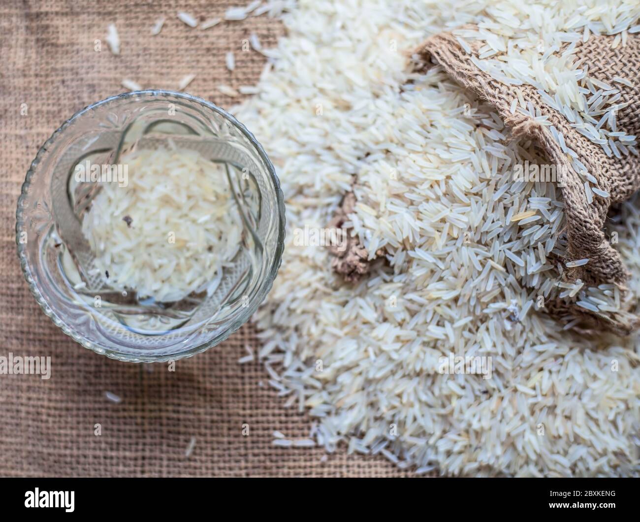 Close up shot of Raw Basmati white rice in a gunny bag on a brown ...