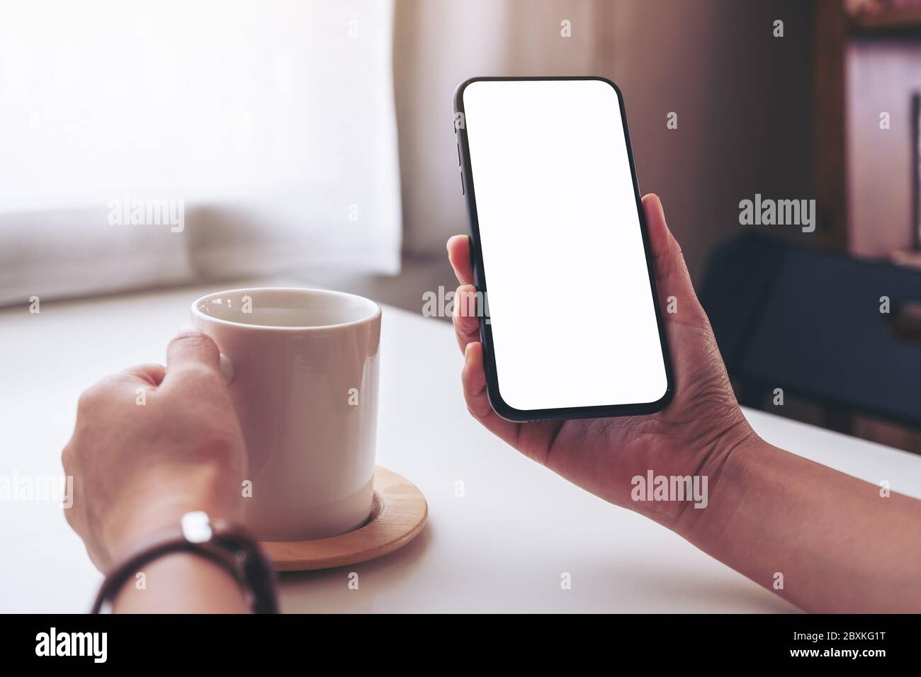 Mockup image of a woman holding black mobile phone with blank desktop ...