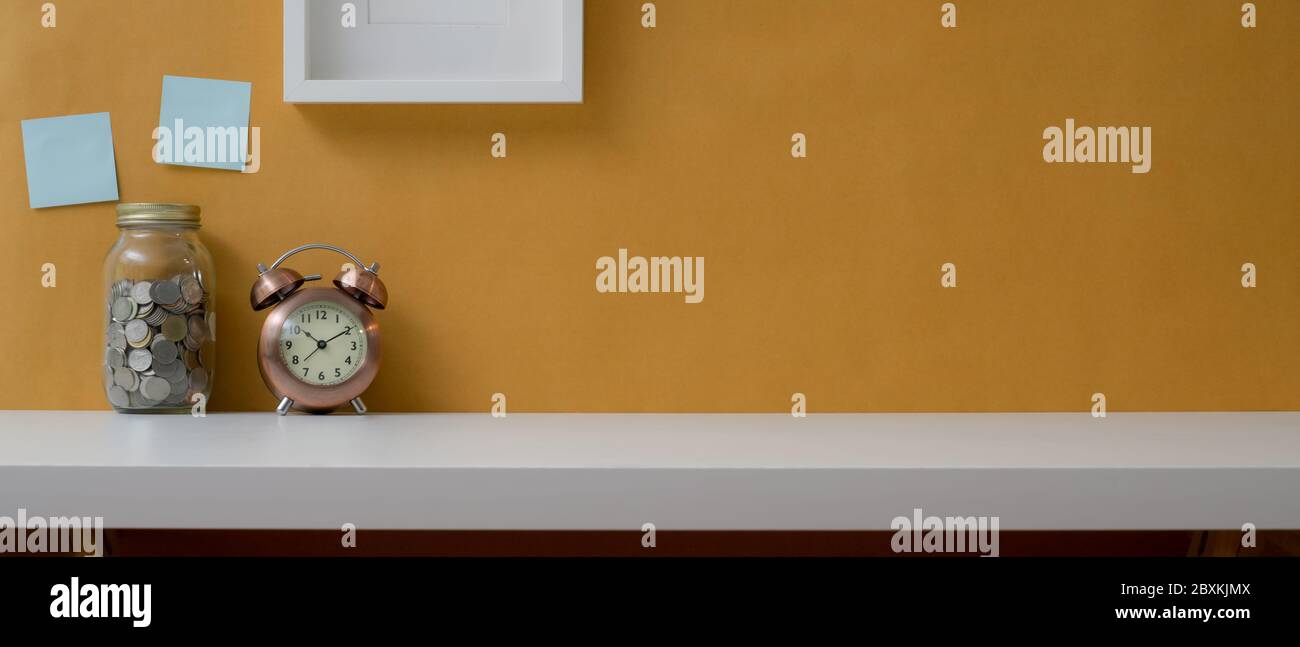 Home interior design with coin jar, clock and copy space on white ...