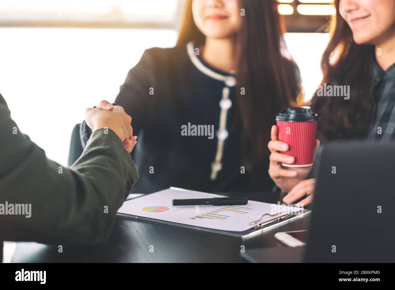 Businesspeople working and shaking hands in a meeting Stock Photo - Alamy