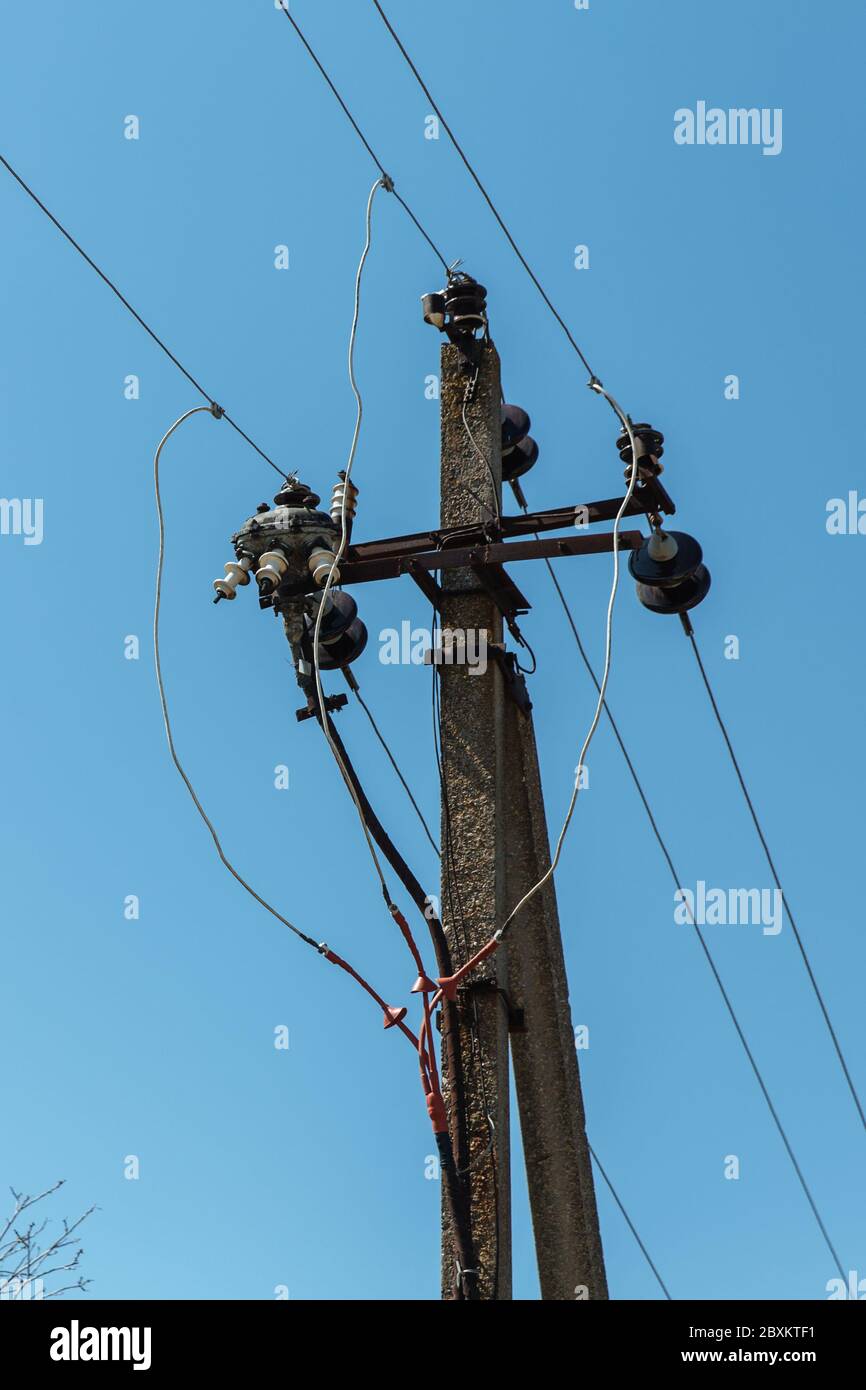 Power line post with electricity cables against a clear sky with white ...
