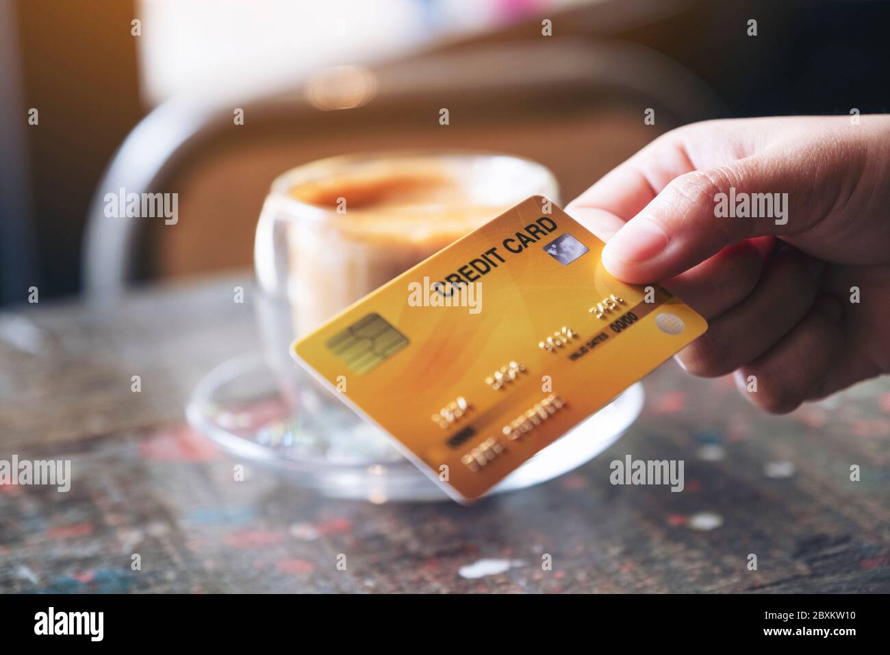 Closeup image of a hand holding and giving credit card Stock Photo - Alamy