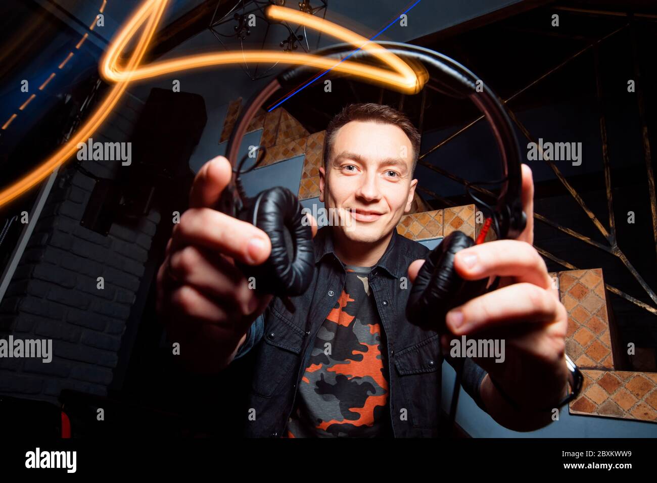 The face of a man with emotions. DJ puts on headphones. Young emotional ...