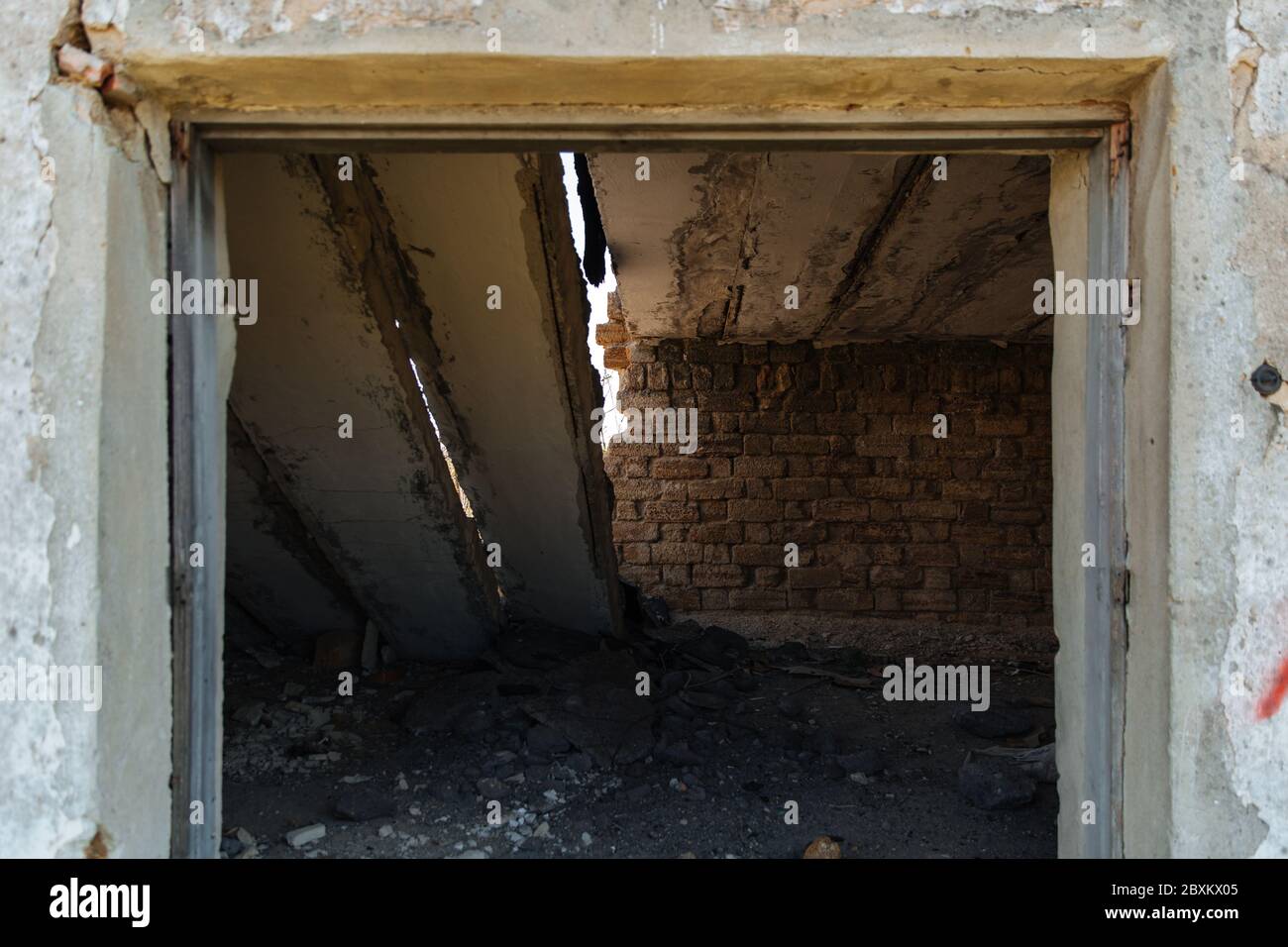 The wall with the doorway in the ruins of the collapse of the ...