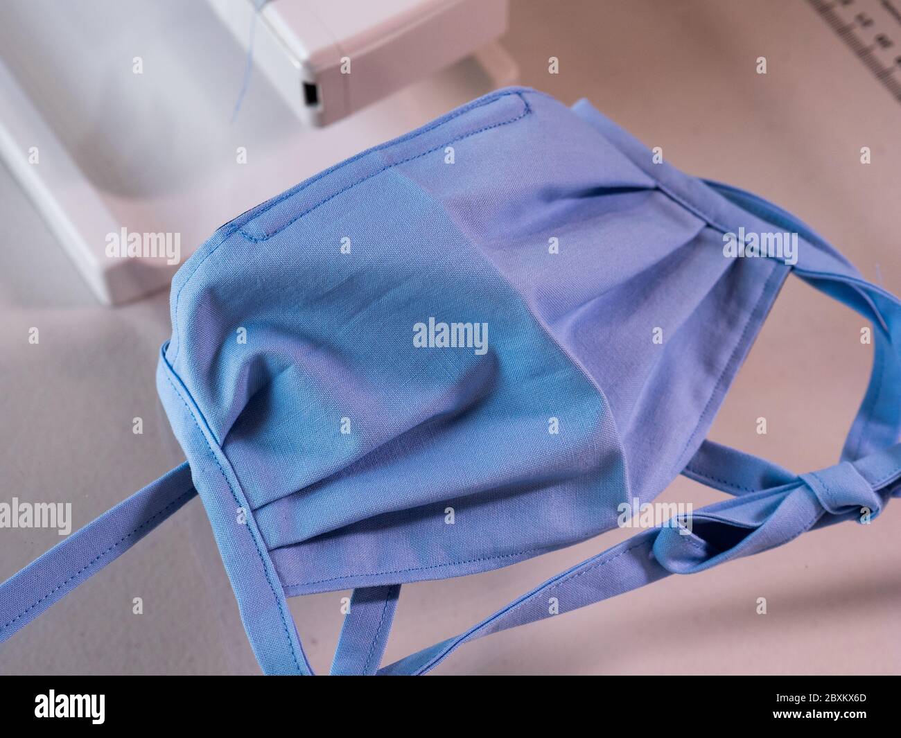 DIY blue cotton homemade face mask on top of glass sewing table Stock ...