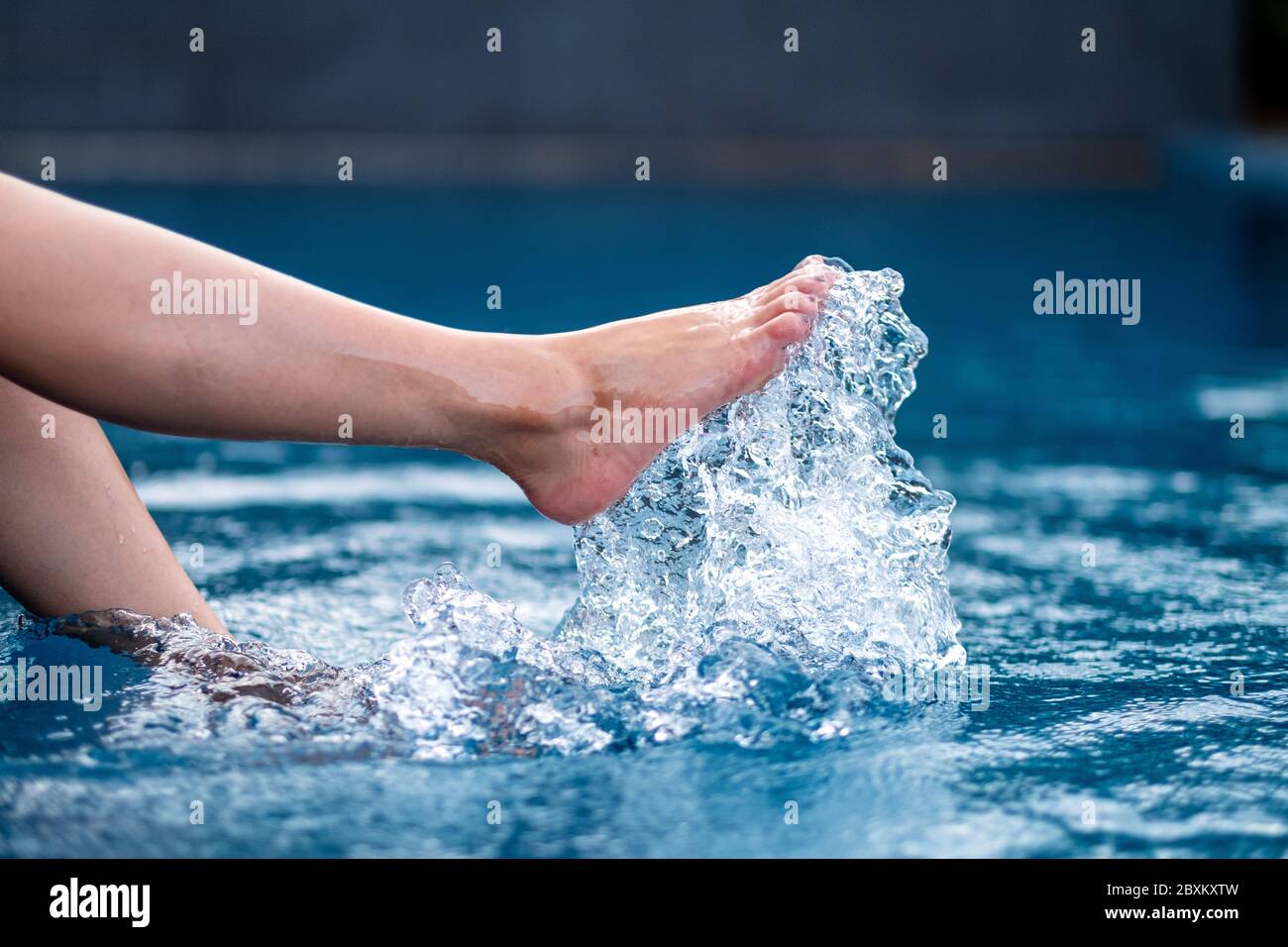 Woman dipping feet in pool hi-res stock photography and images - Alamy