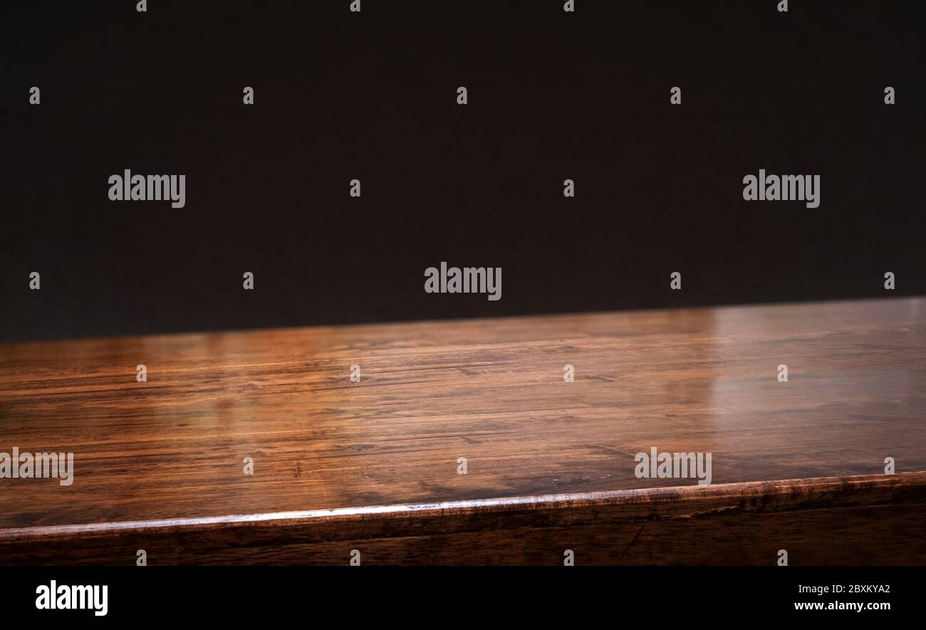 black background.Empty diagonal brown wooden table with blur black ...