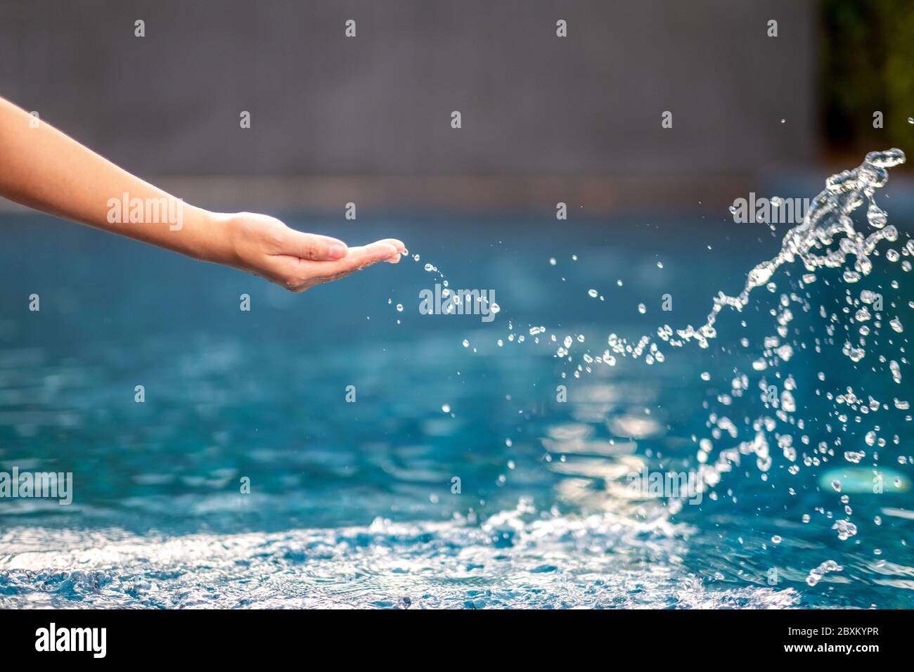 Closeup image of a hand splashing water in the pool Stock Photo - Alamy