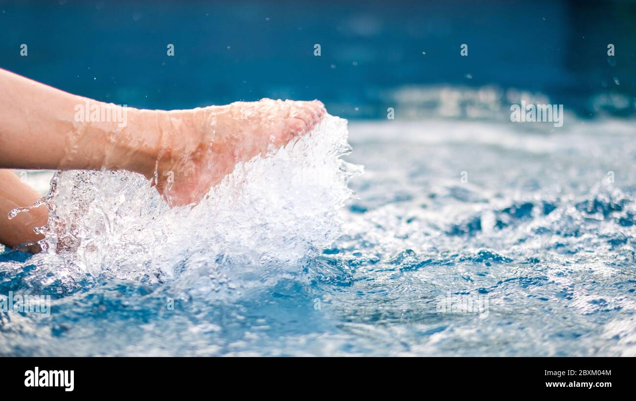 Woman dipping feet in pool hi-res stock photography and images - Alamy