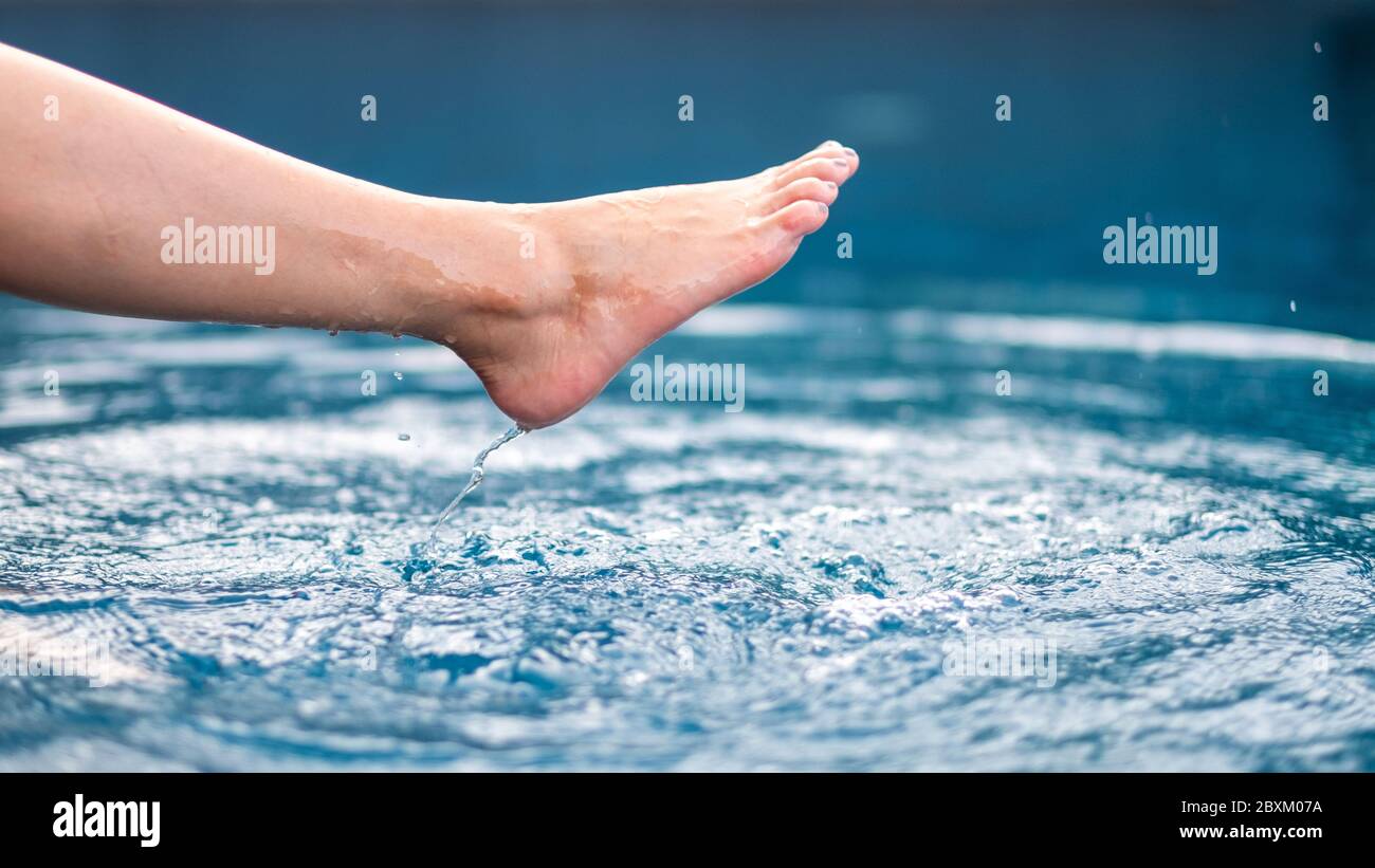 Woman dipping feet in pool hi-res stock photography and images - Alamy