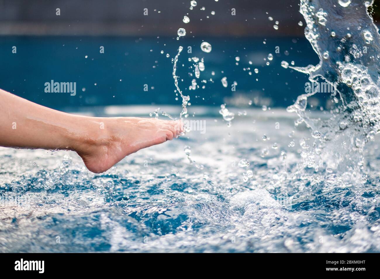 Woman dipping feet in pool hi-res stock photography and images - Alamy